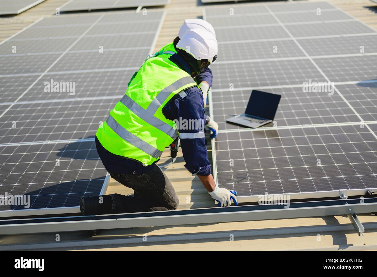 Engineers with safety helmet checking solar system at solar power farm ...