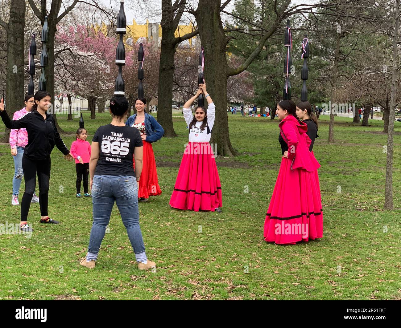 Women and girls balance bottles stacked on their heads, a traditional ...