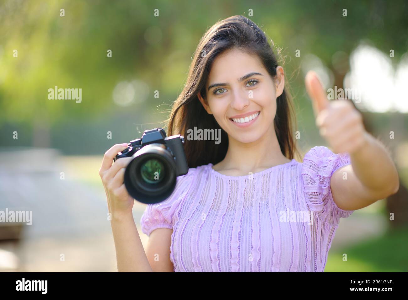 Front view portrait of a happy photographer gesturing thumbs up Stock ...