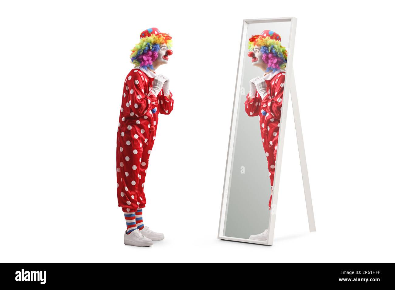 Full length shot of a clown putting on costume in front of a mirror ...