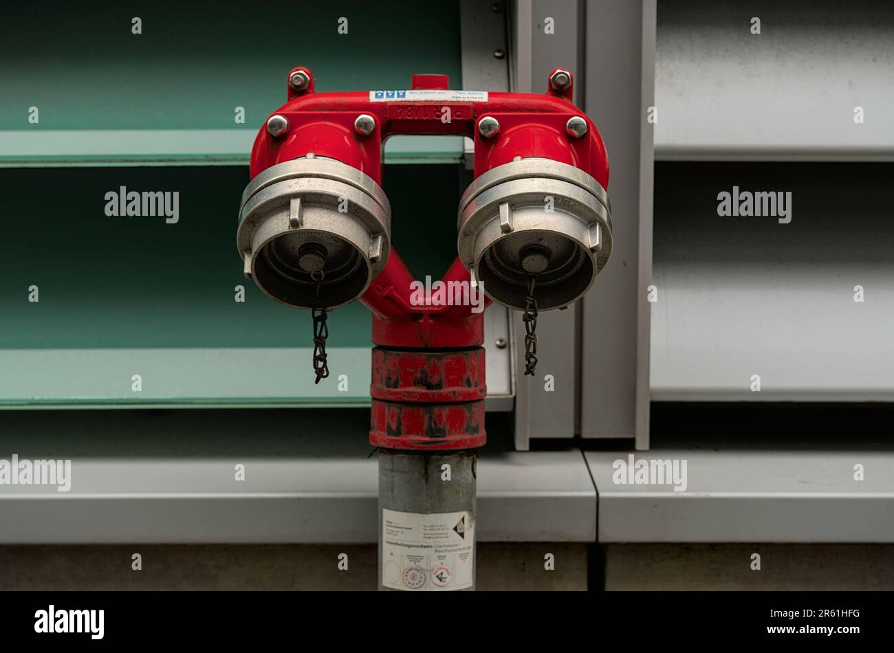 A close-up view of a bright red fire hydrant standing atop a concrete ...