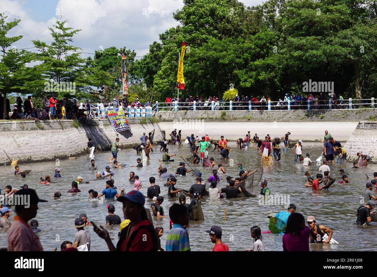 People fishing on gropyok iwak at sumber jembangan. Gropyok iwak means ...
