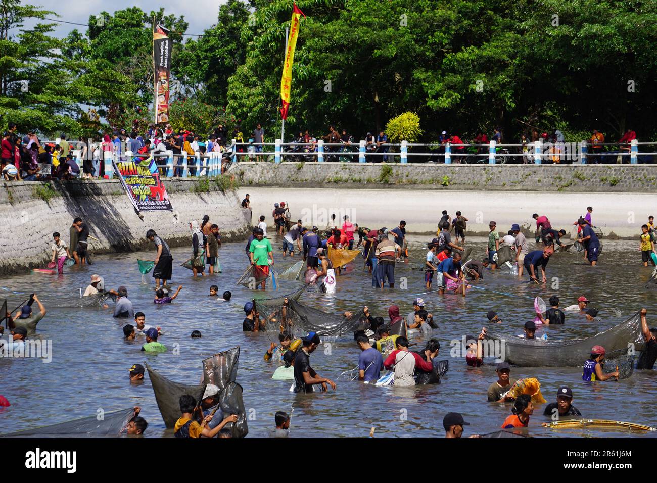 People fishing on gropyok iwak at sumber jembangan. Gropyok iwak means ...