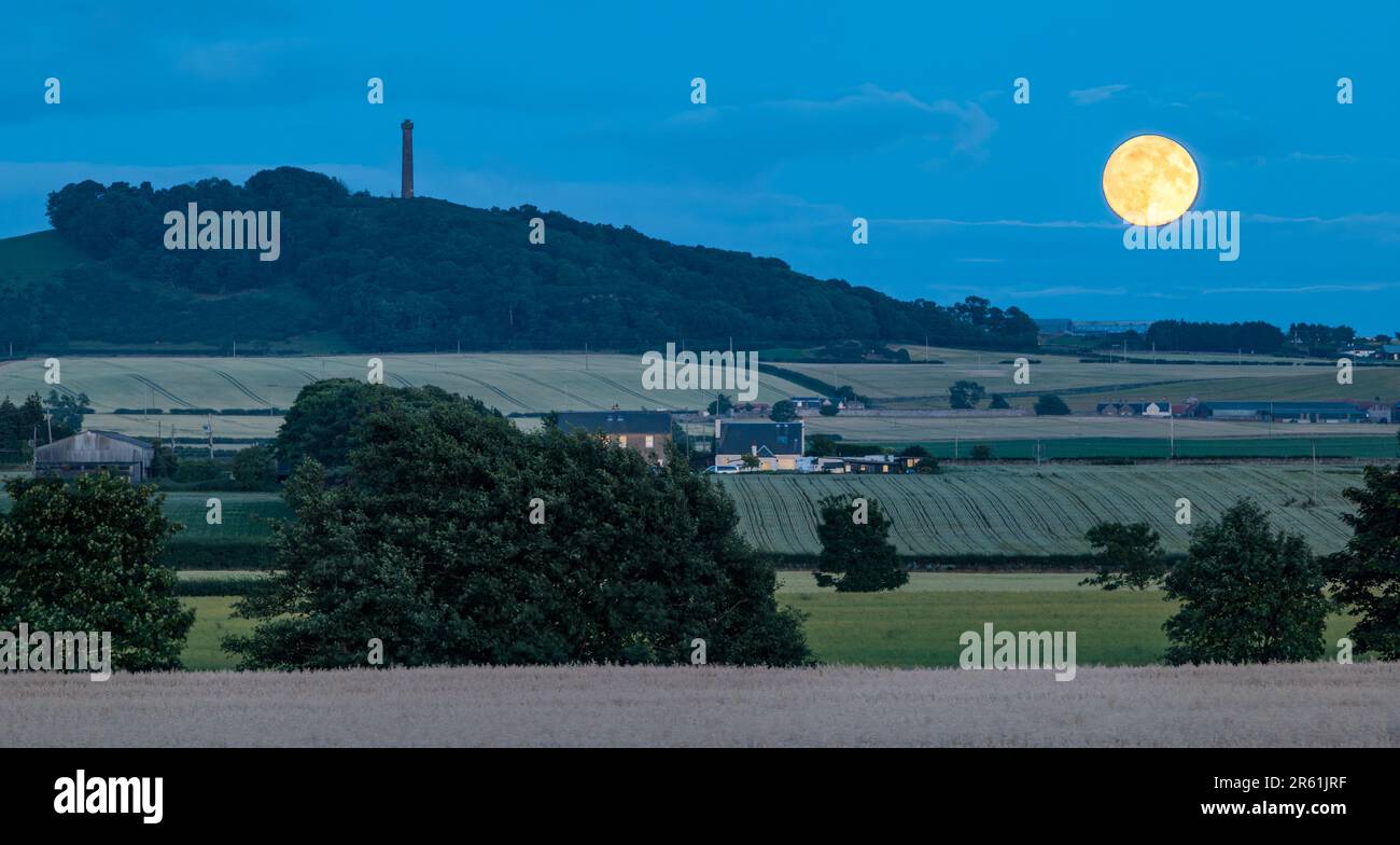 Supermoon full moon rising next to Byres Hill at dusk or twilight, East ...