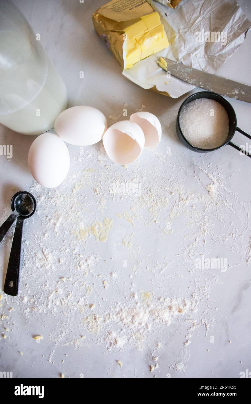 A kitchen countertop with flour and a few eggs, ready to be used in a ...