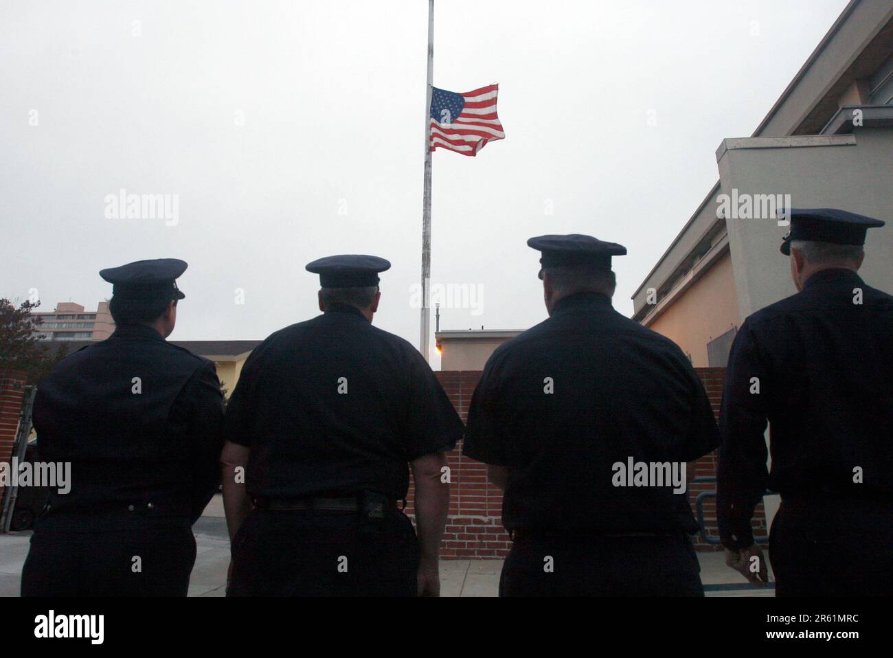 Firefighters at SFFD Station 5 stand at attention while the flag is ...