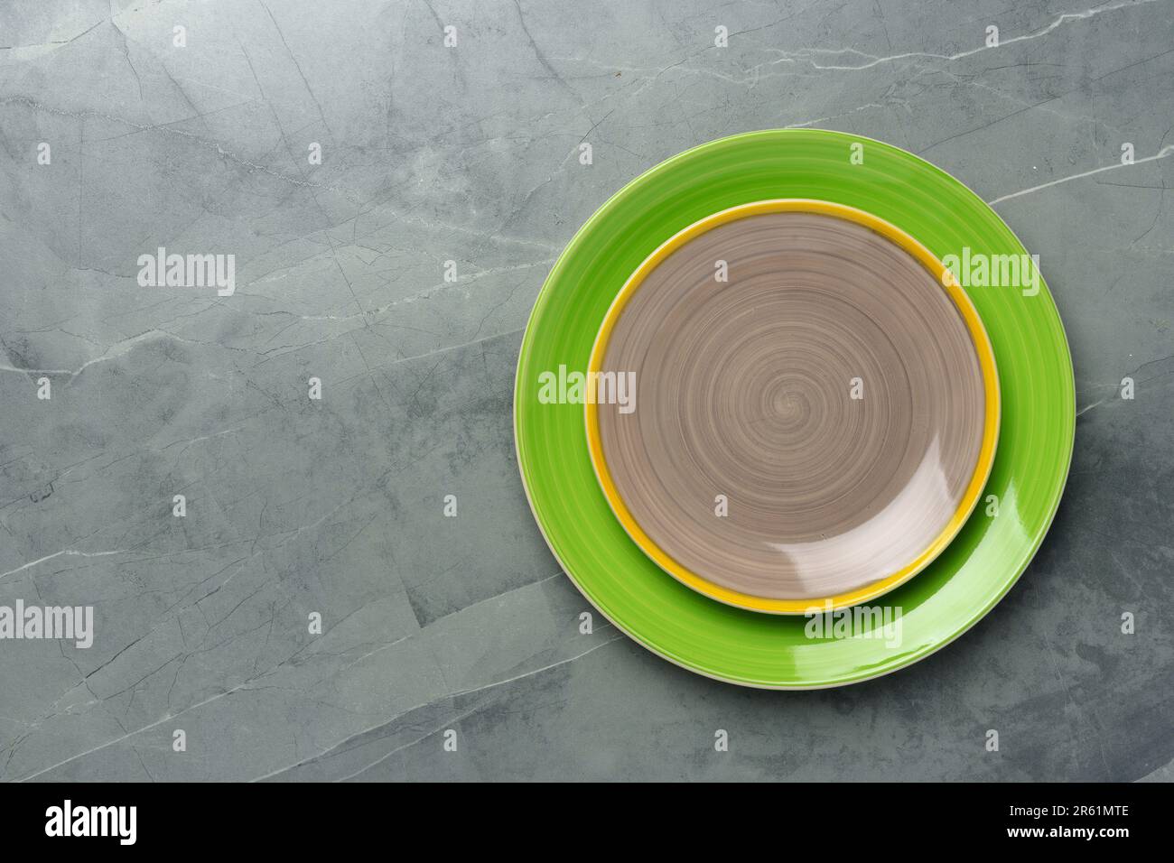 Color ceramic plates on gray background top view Stock Photo - Alamy
