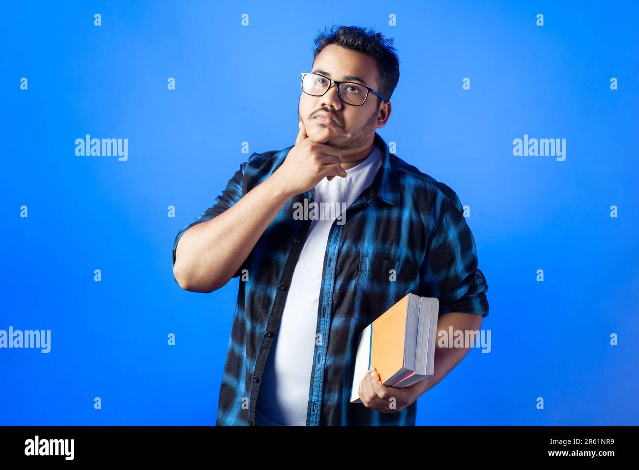 An Indian adult student holding books and thinking about future ...
