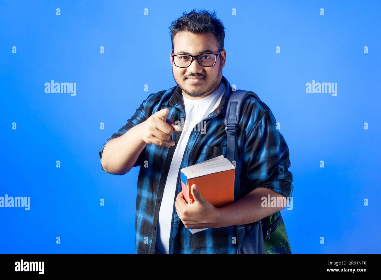 happy indian male student pointing finger towards camera in blue ...