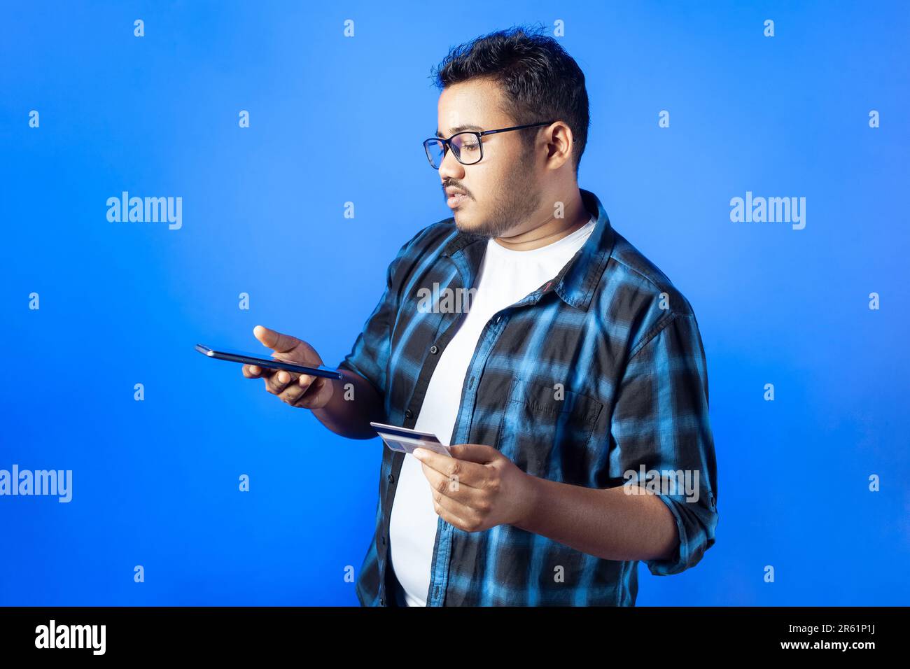 One overweight Indian University student using smart phone and credit ...