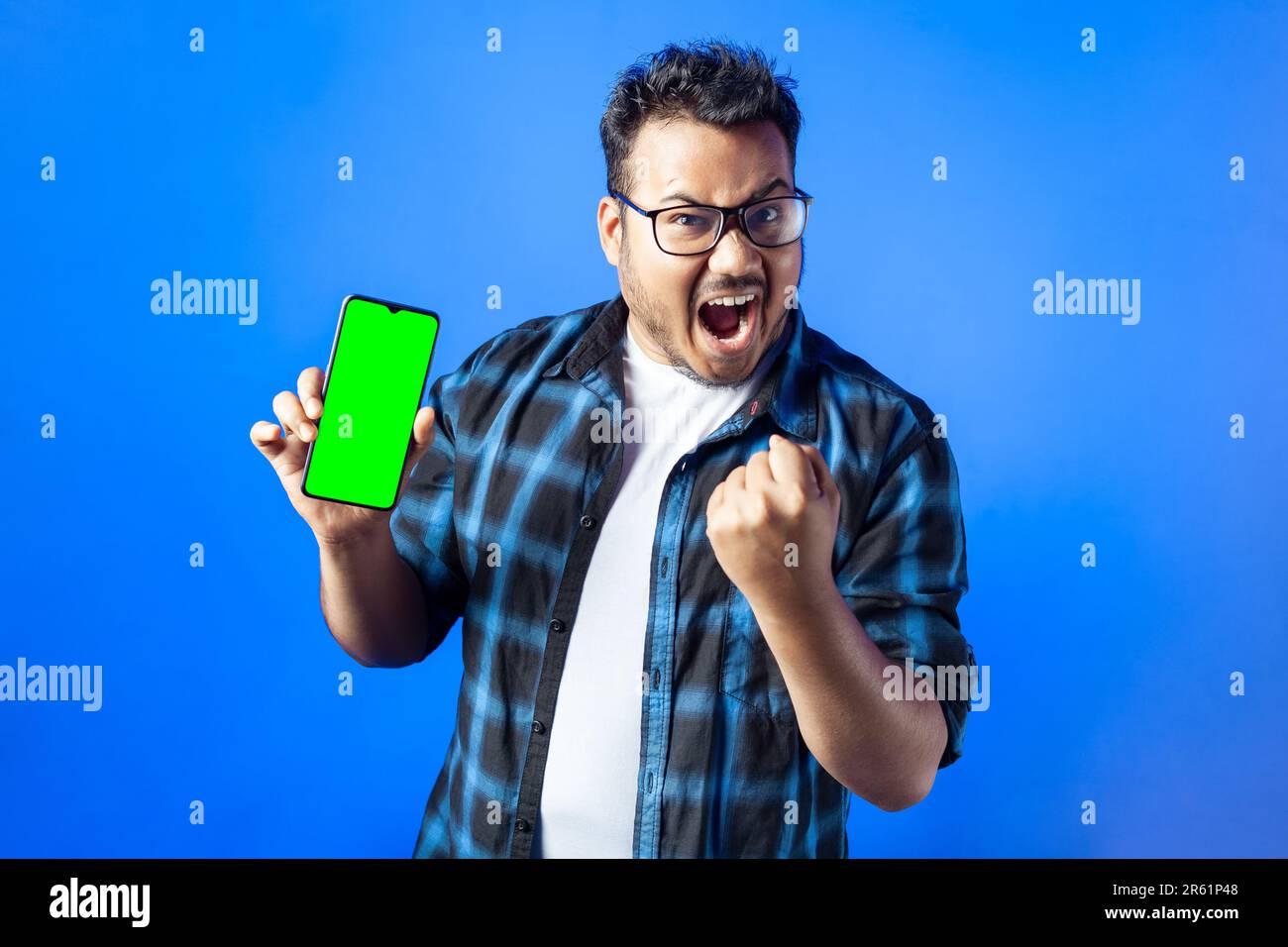 portrait of an excited Indian Caucasian man cheering and showing smart ...