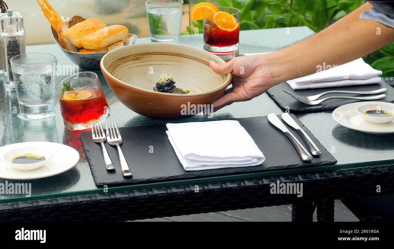 A waiter prepares to serve a table at a beachfront restaurant Stock ...