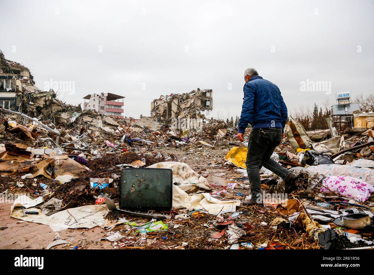 A man stands in front of a destroyed home, looking in disbelief at the ...