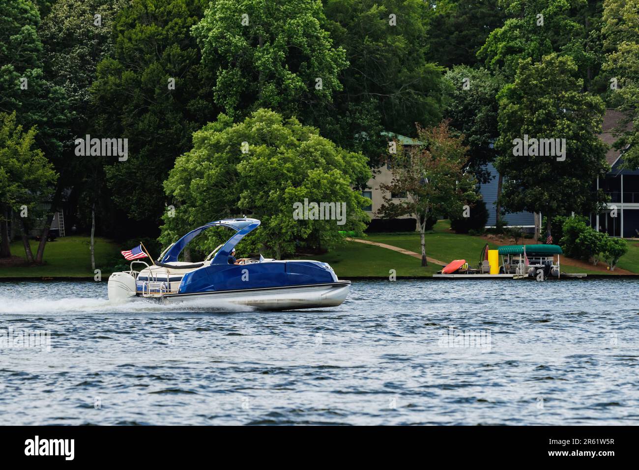 Boater on blue pontoon boat enjoying summer day on lake. Pontoon party ...