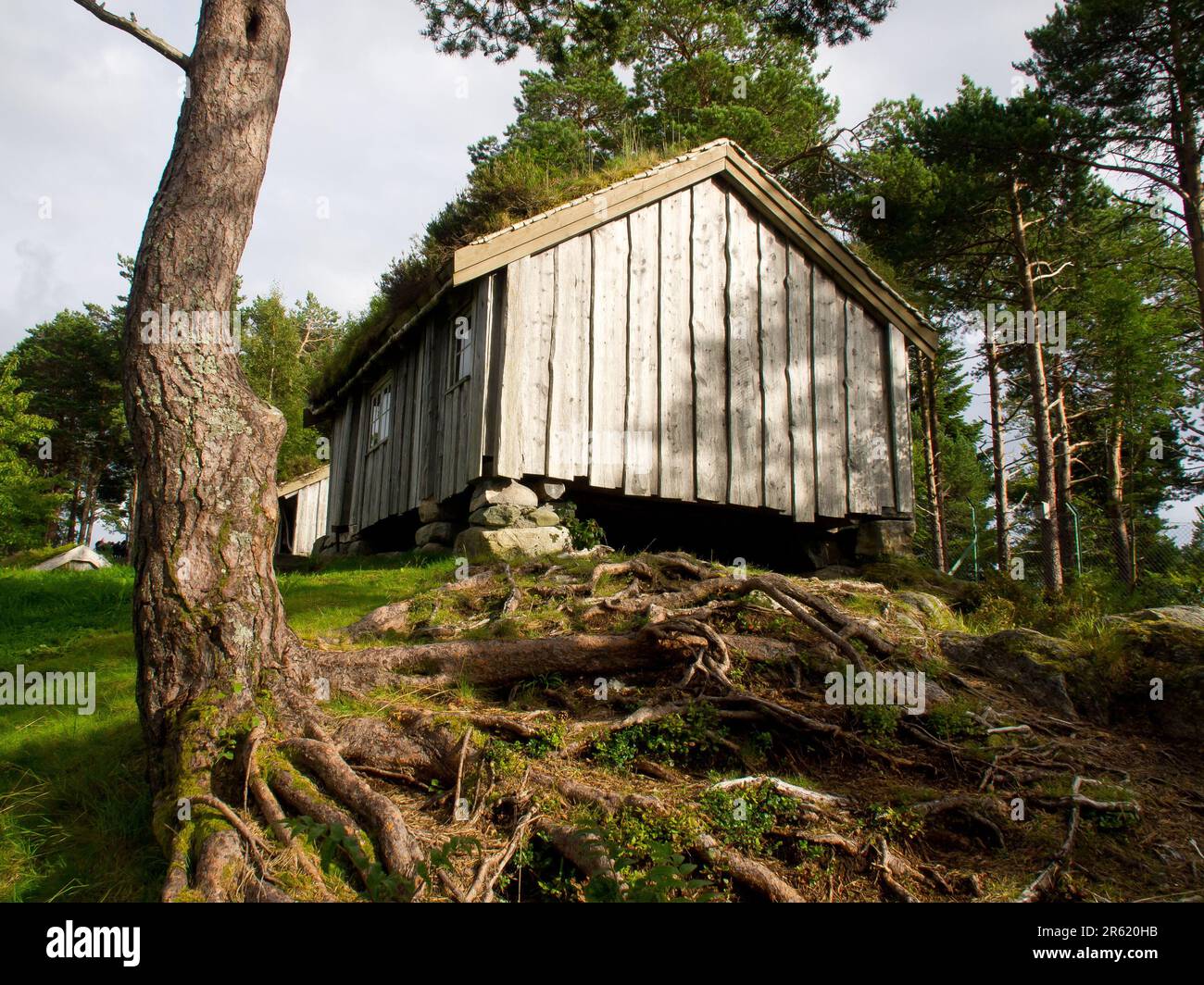 This image features a large, imposing structure situated atop a grassy ...