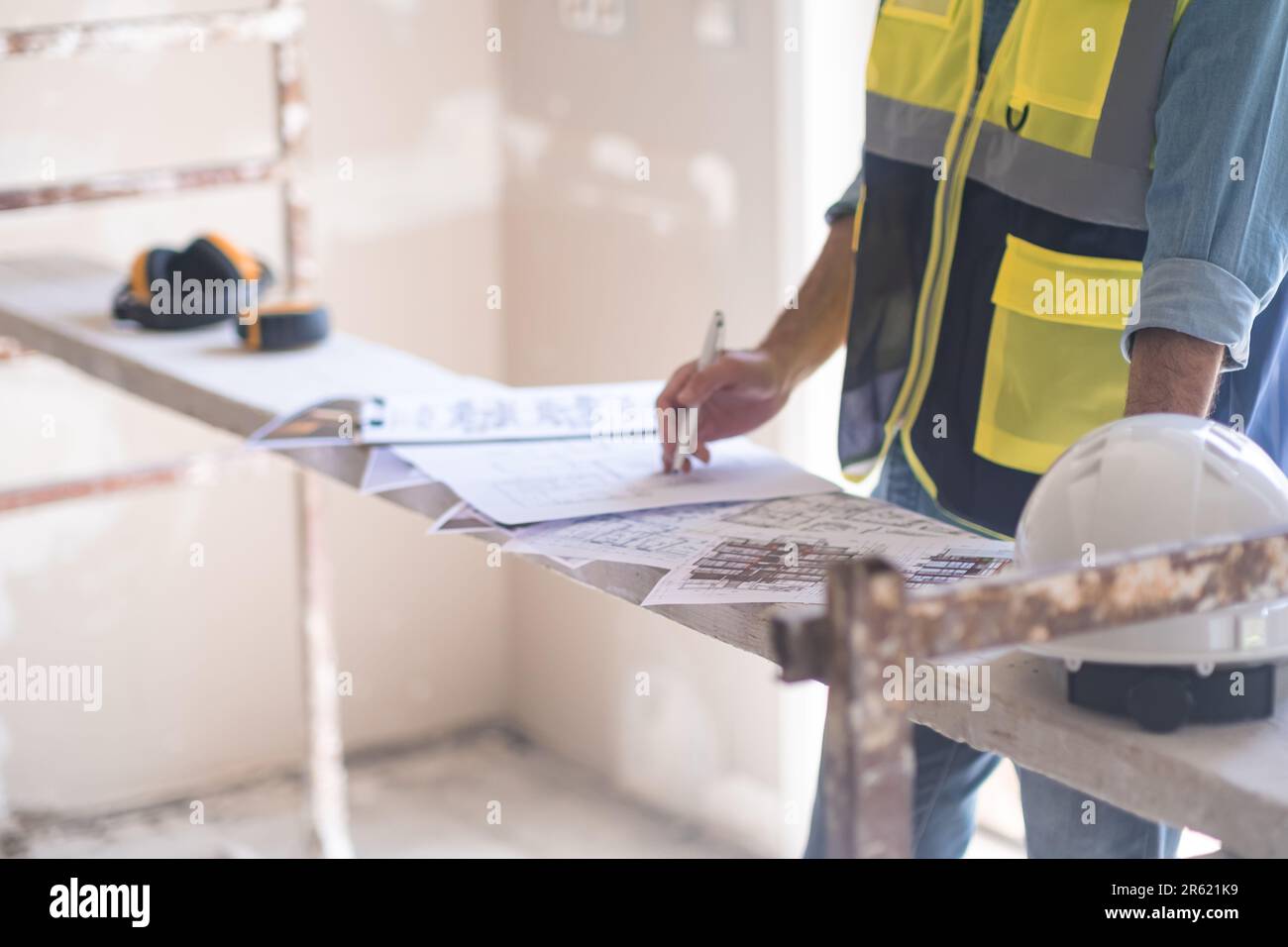 Worker in professional uniform editing and correcting construction ...
