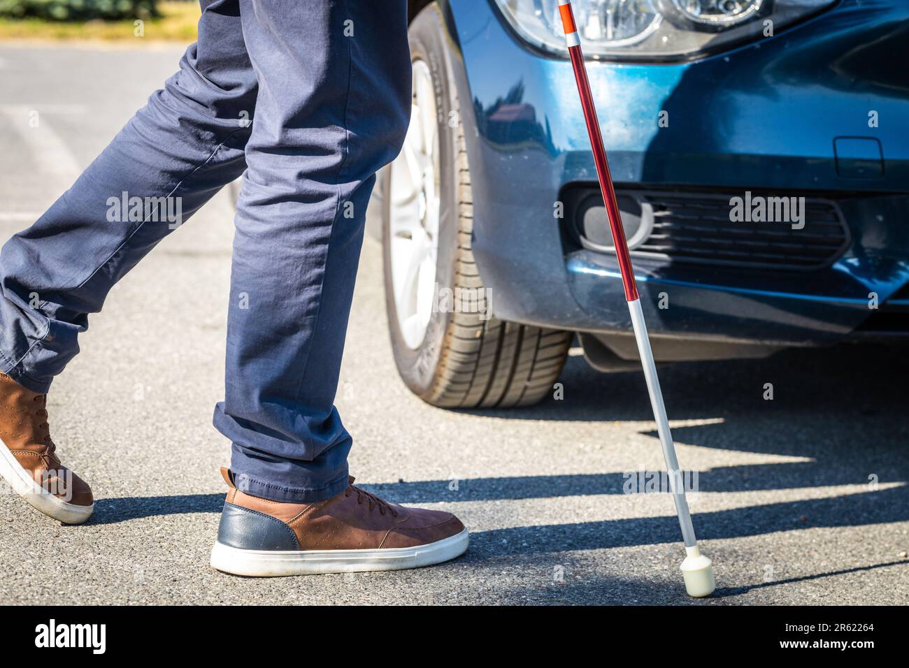 blind person with cane walking in front of car, Concept, Disability ...