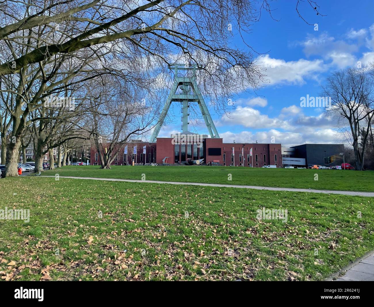 A modern multi-story building stands in the foreground, with a tall ...