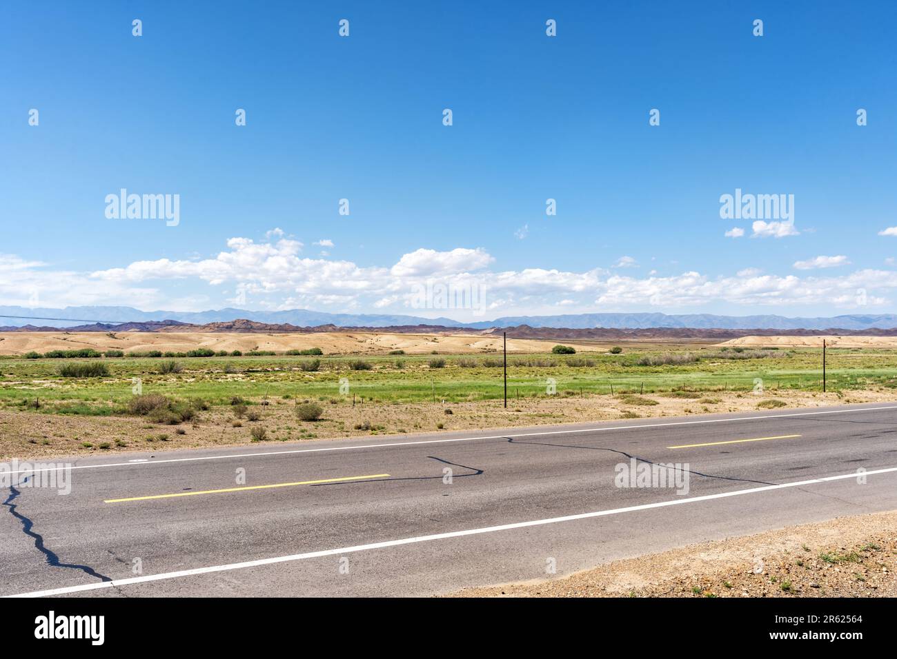 An idyllic scene of an empty paved road stretching out under a pristine ...