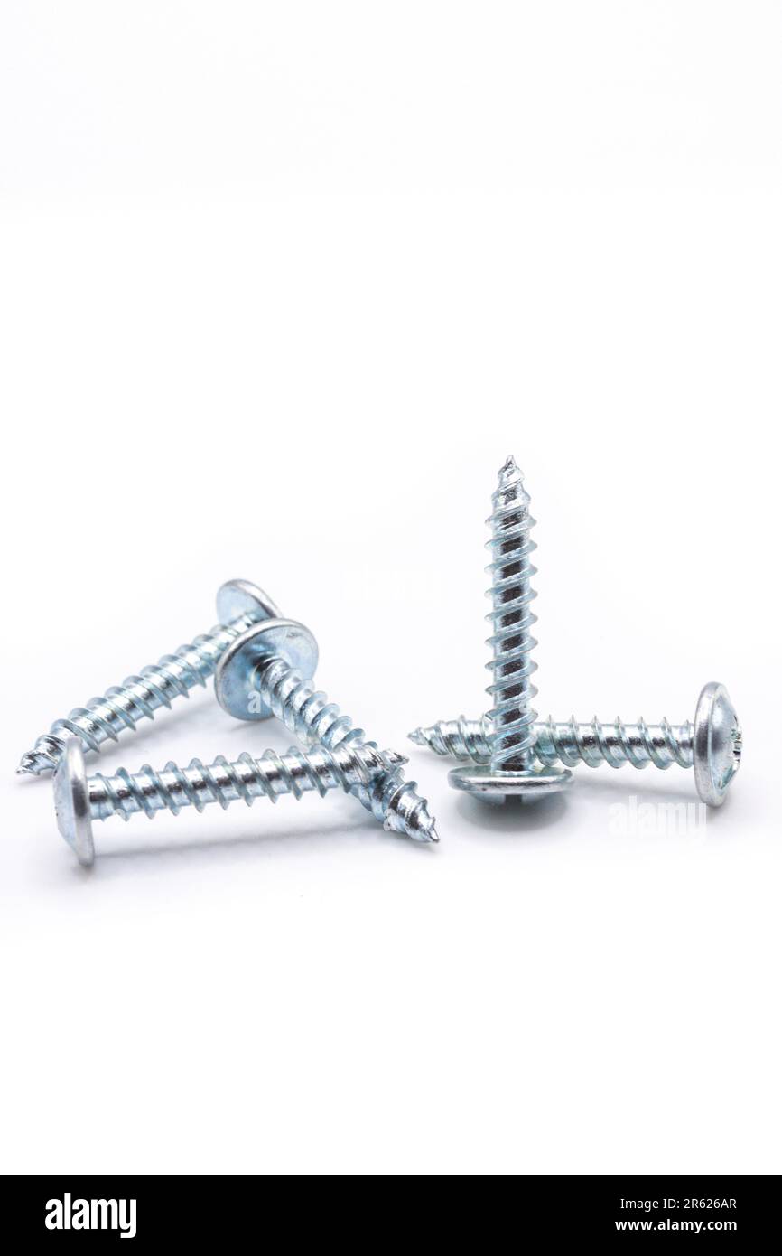 An isolated image of two silver screws perched on top of one another on ...