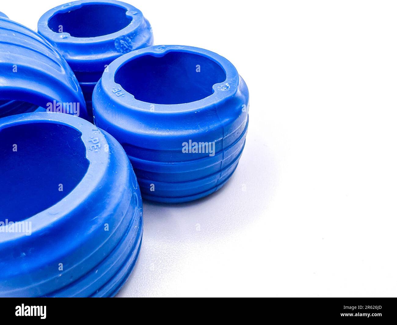 An assortment of blue plastic tube fittings, arranged in a stack on a ...