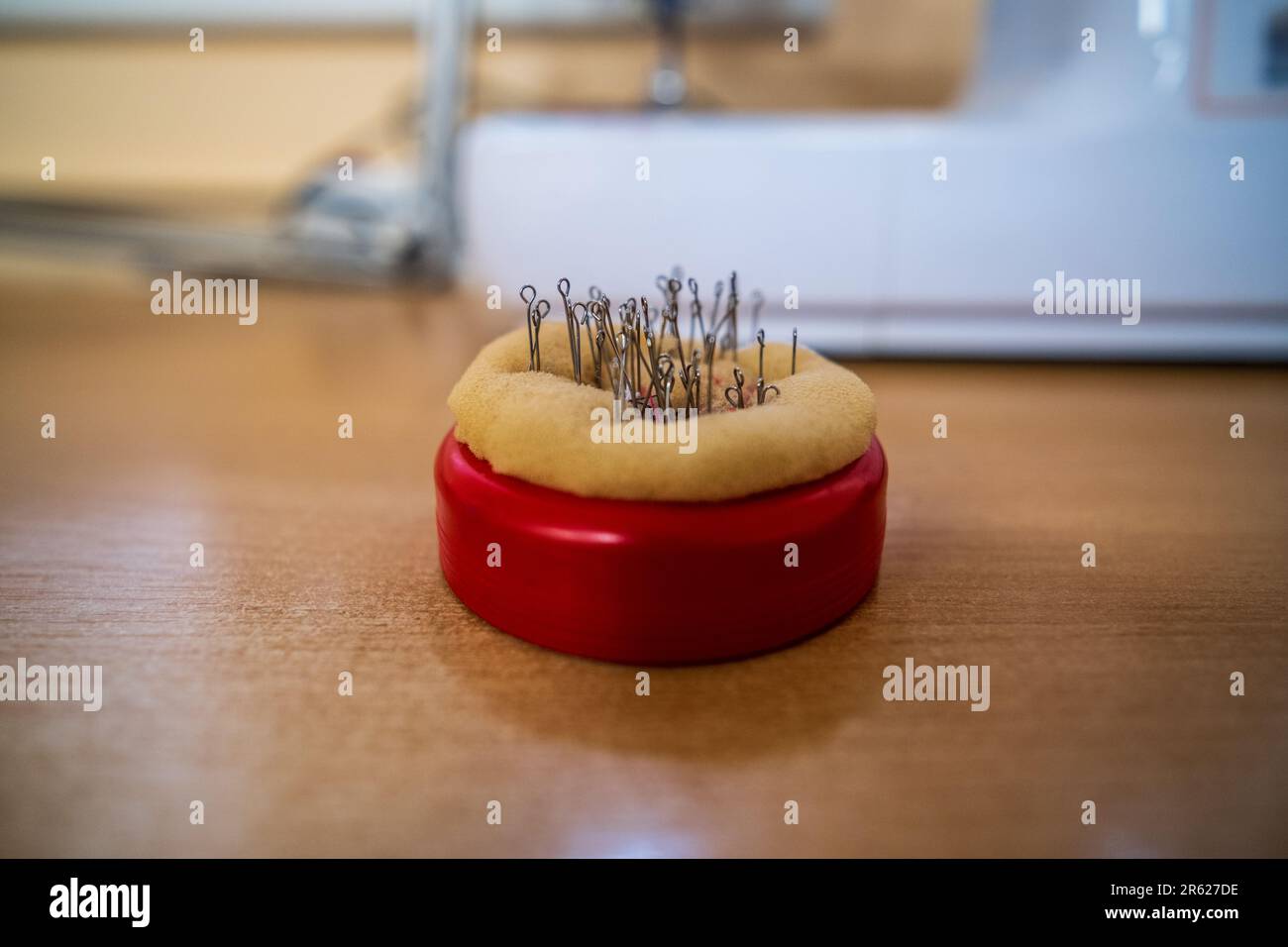 A lot of needles stuck in a soft material red container for storage ...