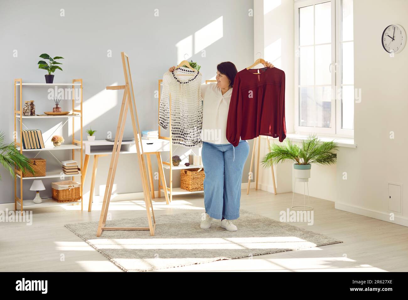 Happy plus size lady looking in mirror and choosing between two ...