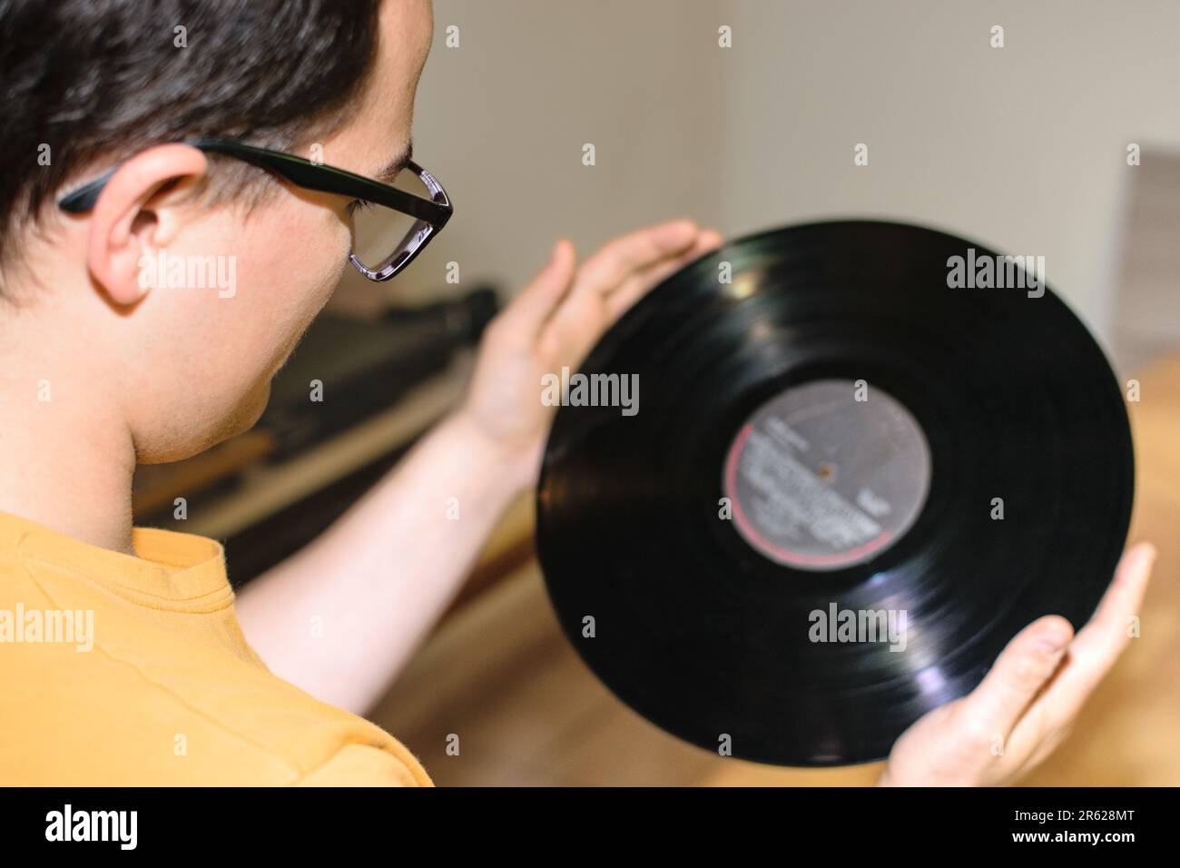 Young man with glasses enjoying while contemplating his vinyl record in ...