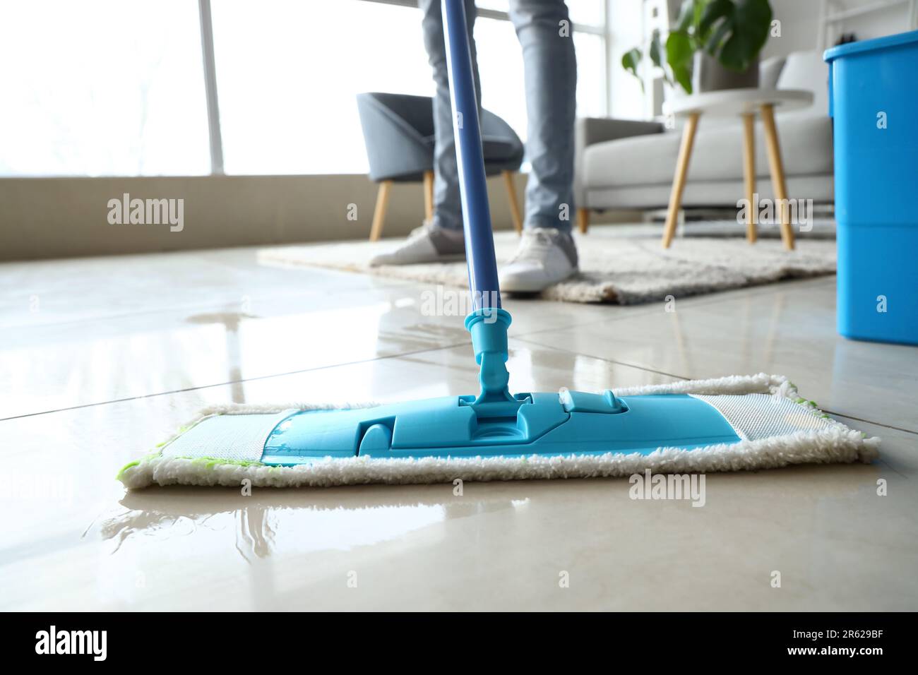 Male janitor mopping floor in living room, closeup Stock Photo - Alamy
