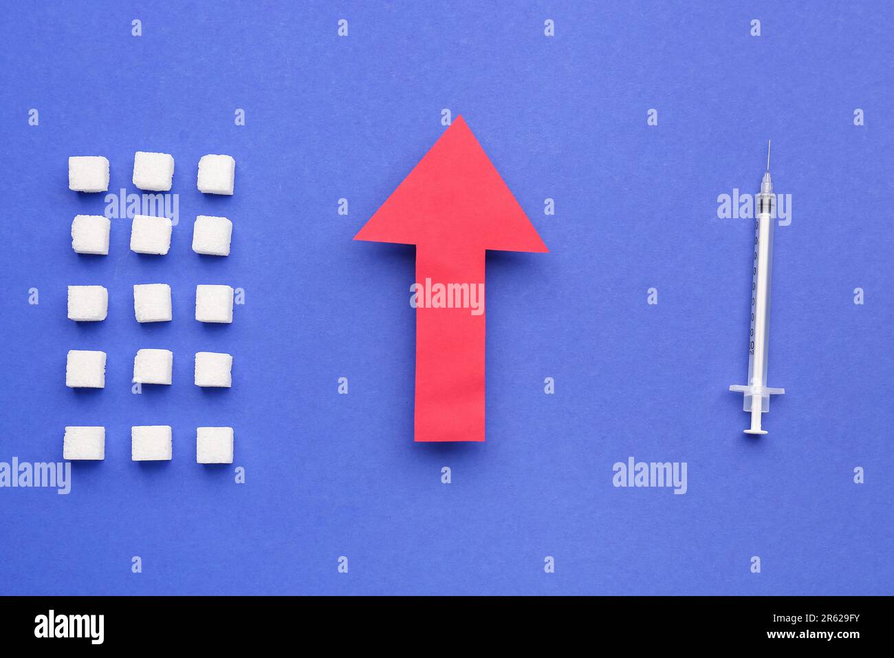 Sugar cubes with syringe for insulin injection and arrow on blue ...