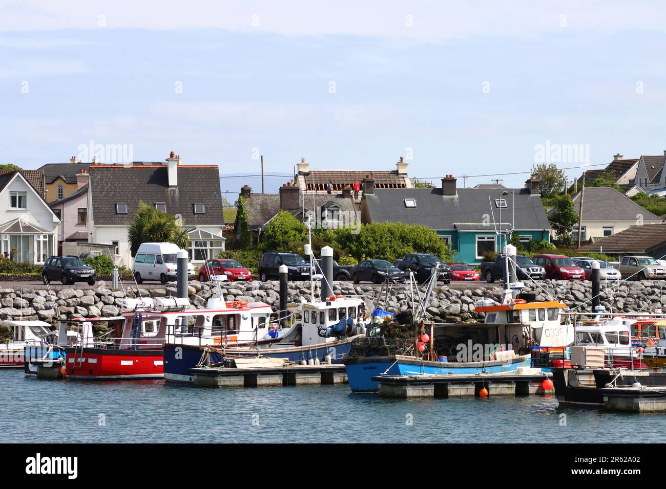 Colorful houses and boats lining Dingle Harbour in Dingle, Ireland ...