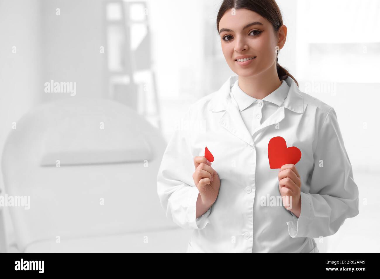 Female doctor with paper blood drop and heart in clinic Stock Photo - Alamy
