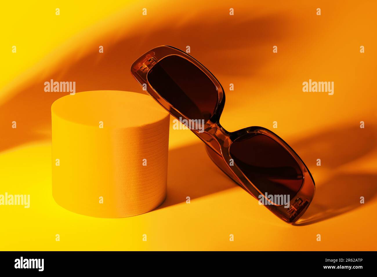 Podium with stylish sunglasses on orange background Stock Photo - Alamy