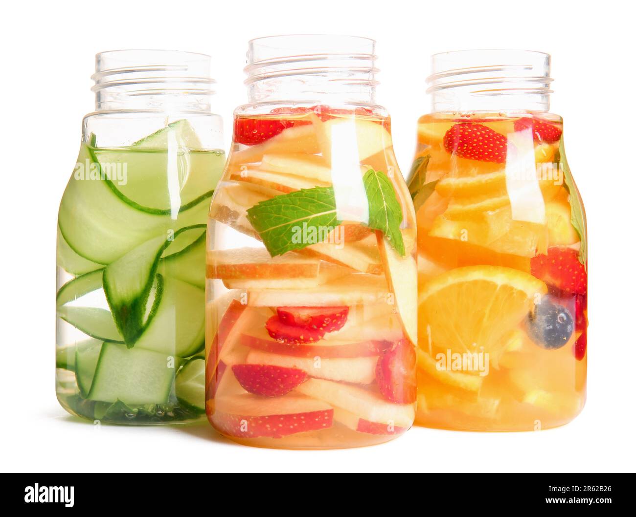Bottles of infused water with different sliced fruits on white ...