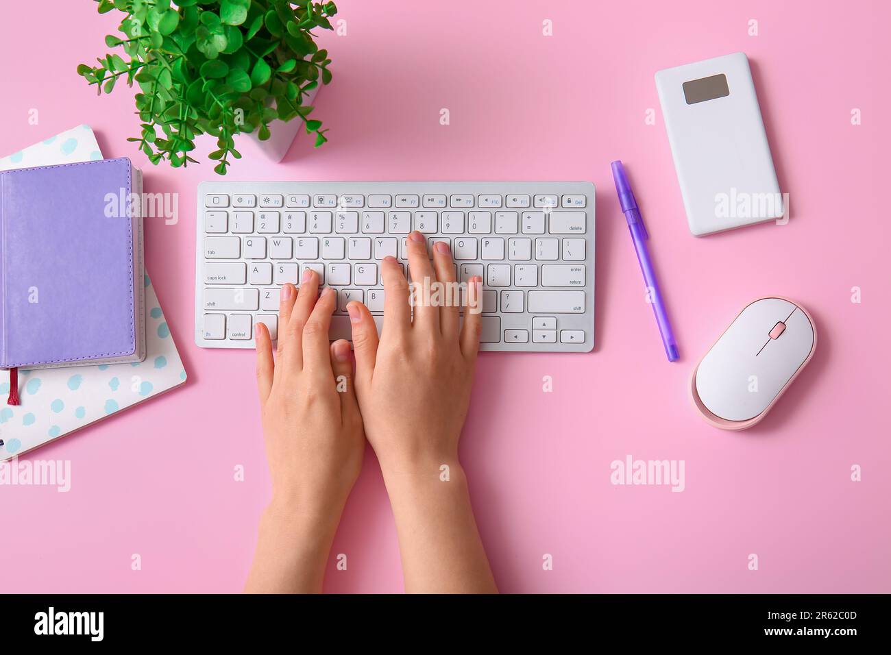 Female programmer using computer keyboard with mouse and notebooks on ...