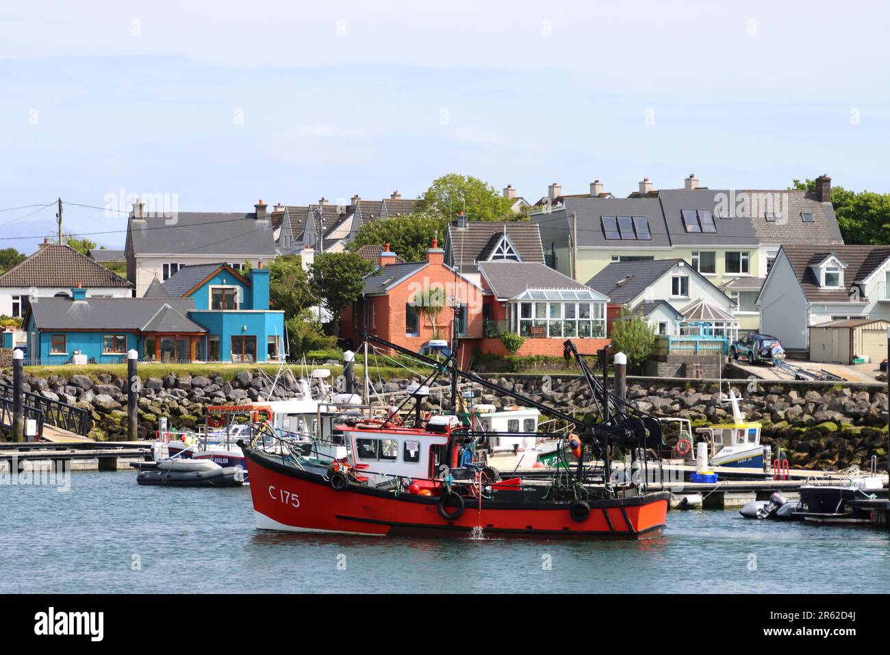 Colorful houses and boats lining Dingle Harbour in Dingle, Ireland ...