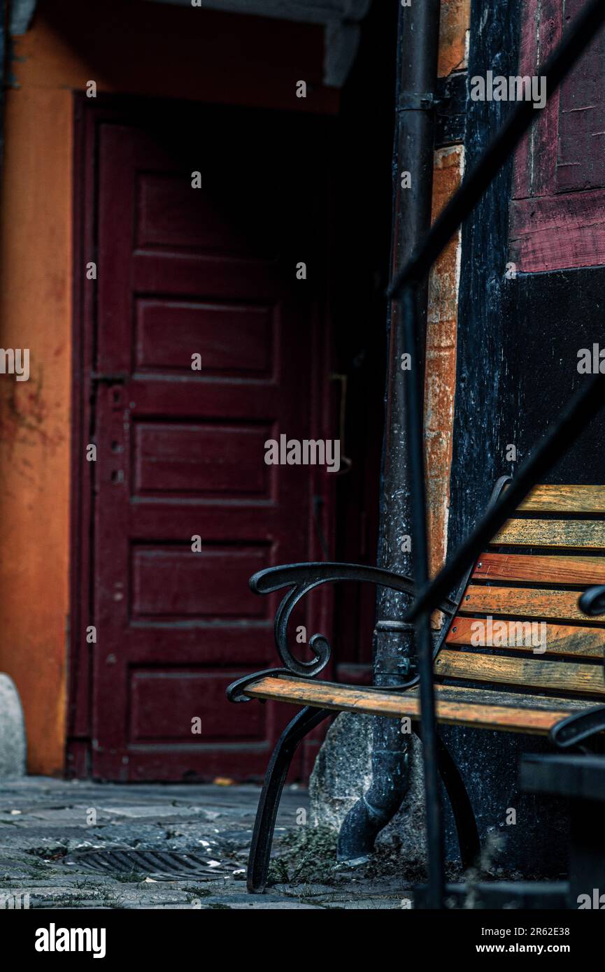 An old fashioned wooden park bench nestled in a secluded alleyway Stock ...