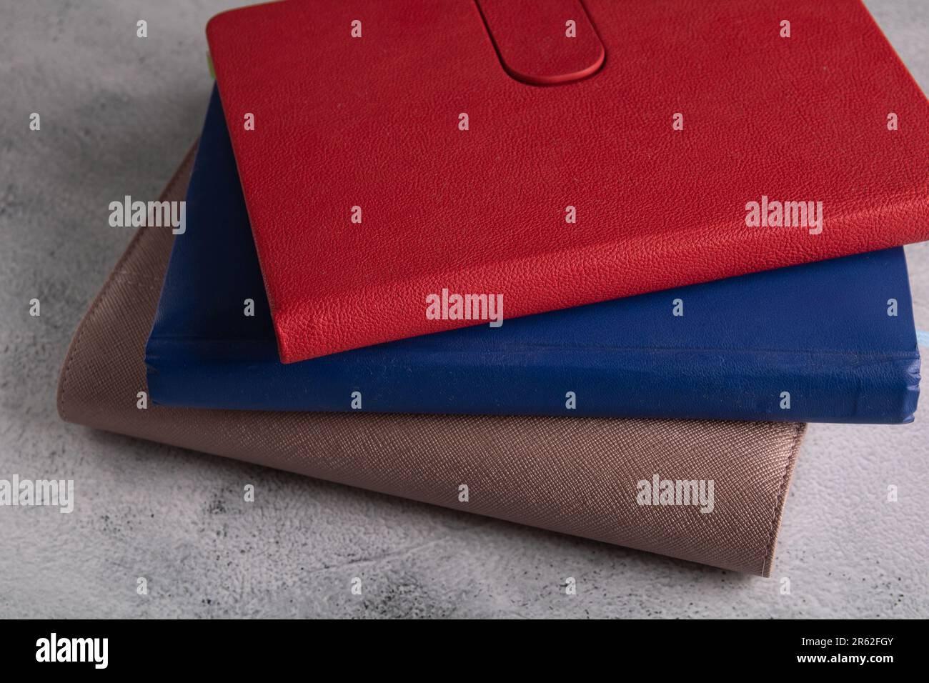 a photo of several notebooks of different colors lying on the table ...