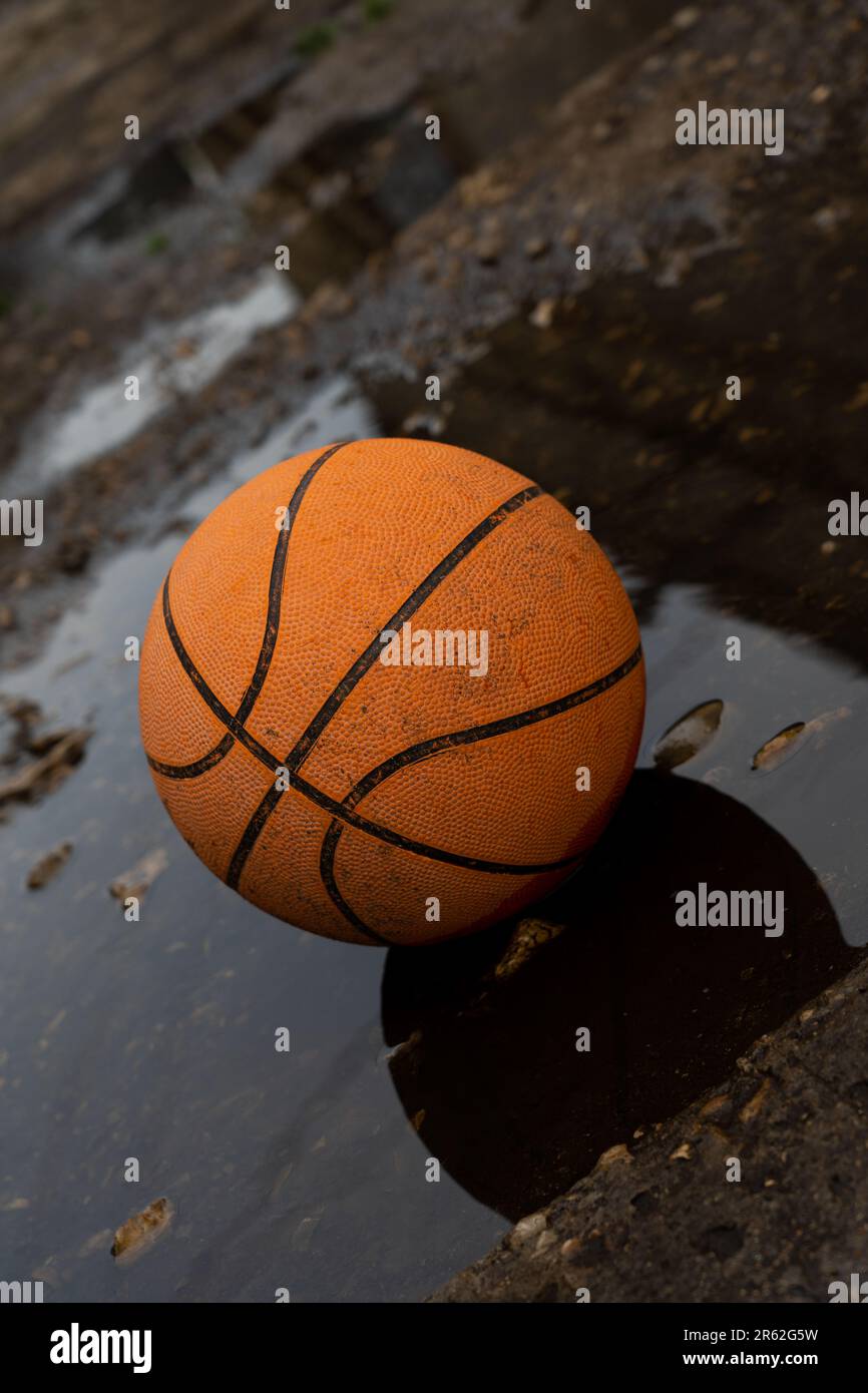 Basketball ball in puddles on the street Stock Photo - Alamy