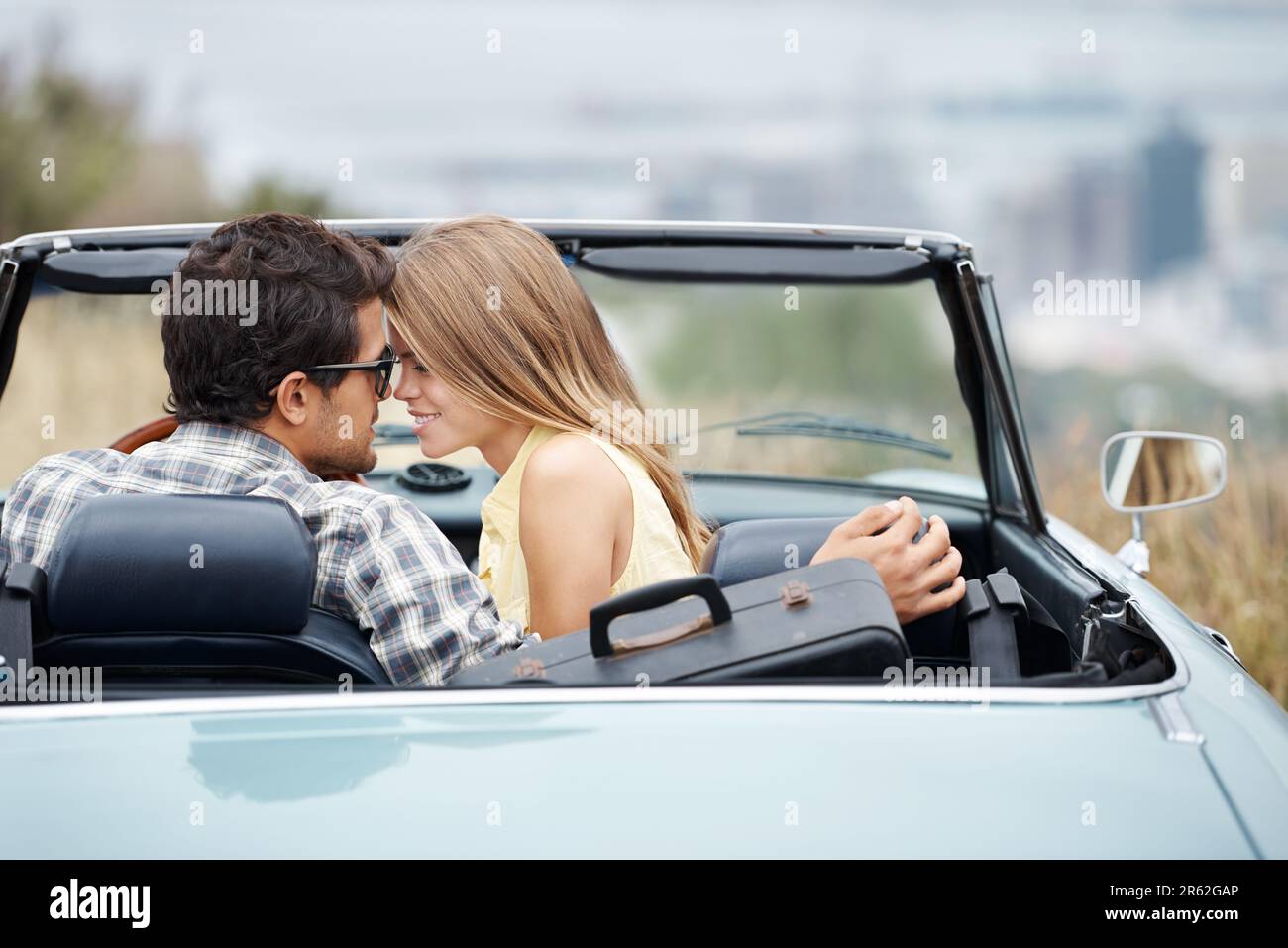 Getting close. An attractive young couple in their convertible while on ...