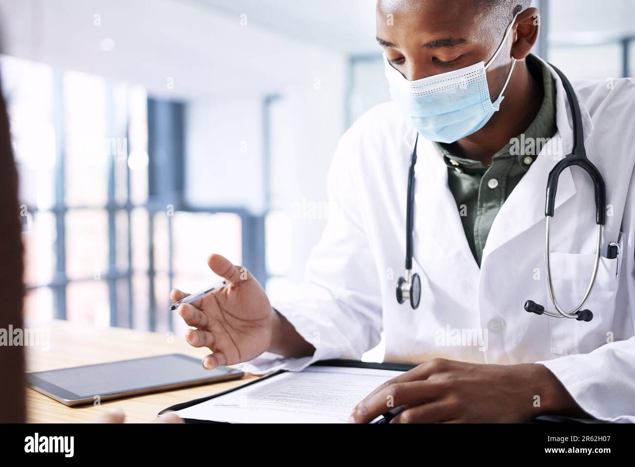 These are the tests we need to run. a young doctor sitting with his ...