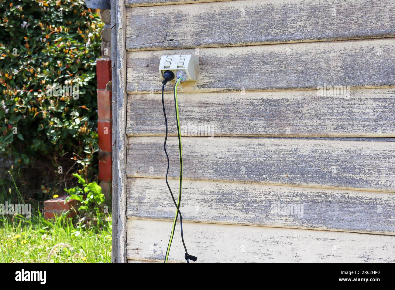 Power cables attached to the power point on an external building wall ...