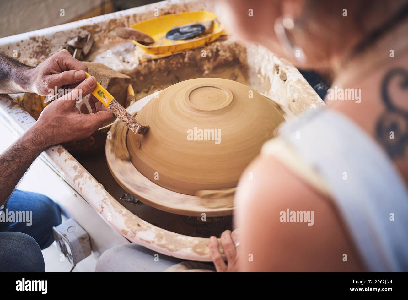 Give me a pottery wheel and clay any day. an unrecognisable woman working with clay in a pottery ...