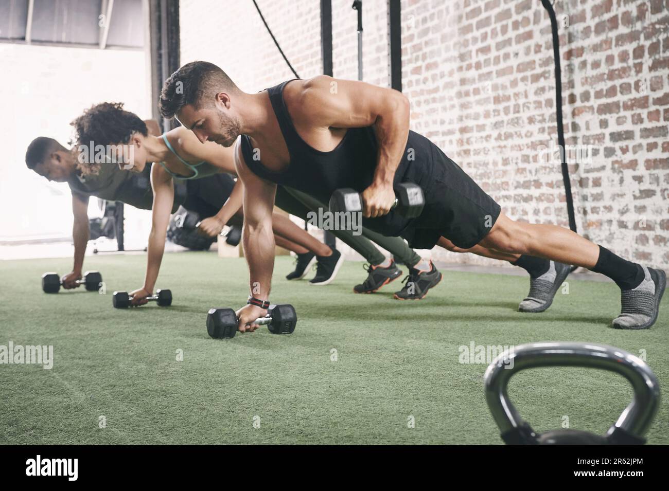 Strengthen your grip. a fitness group using dumbbells while doing push ...