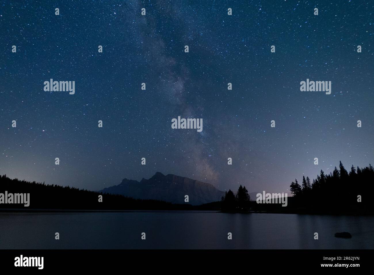 A stunning nightscape with a lake and mountain illuminated by the night ...