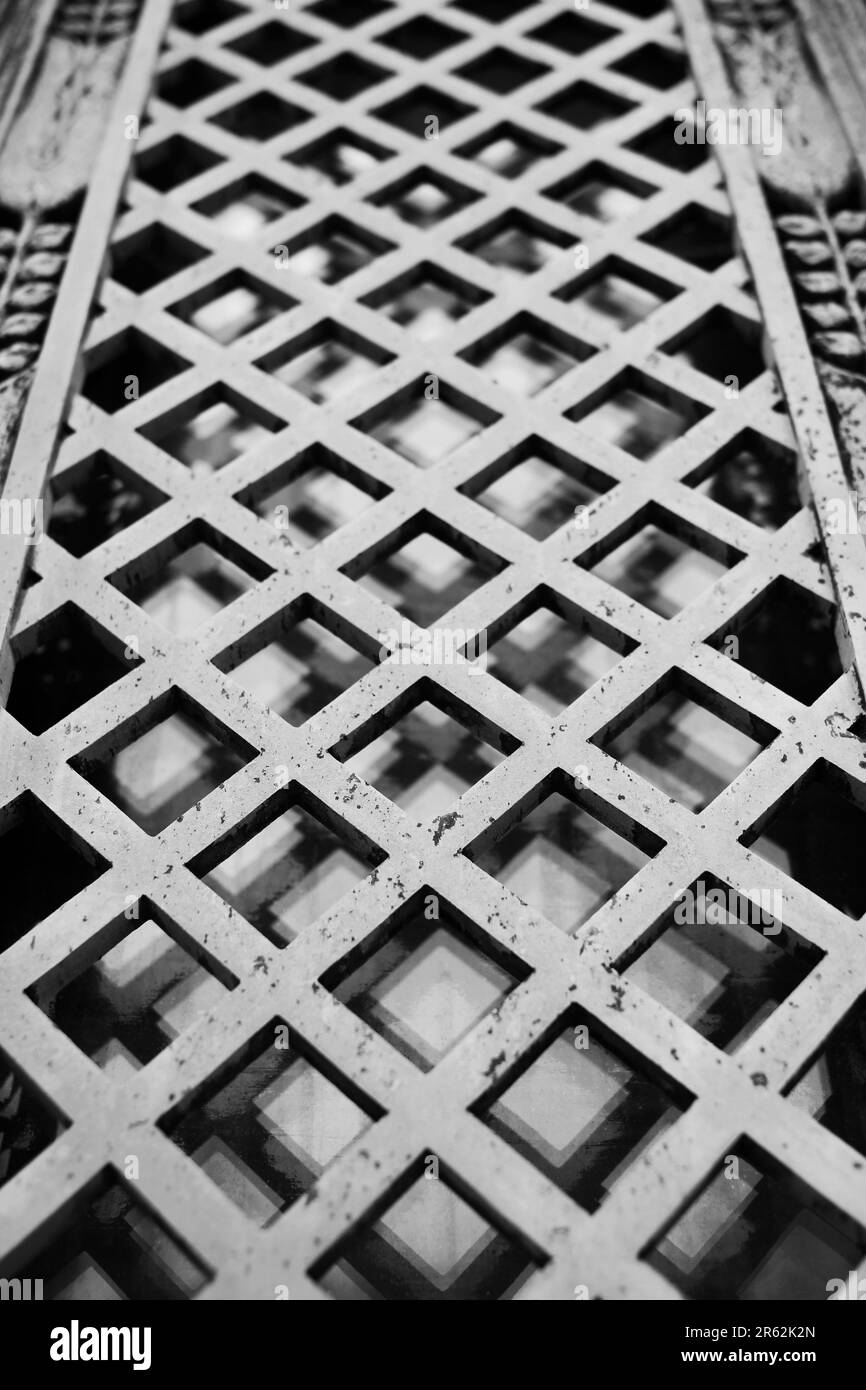 A decorative copper metal fence with a square grid pattern in a black ...
