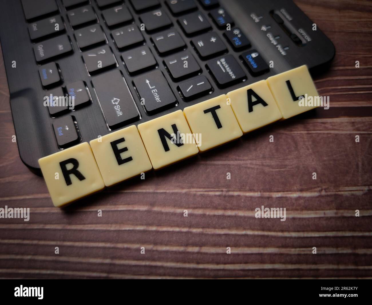 A keyboard and wooden blocks with the word Rental on wooden background ...