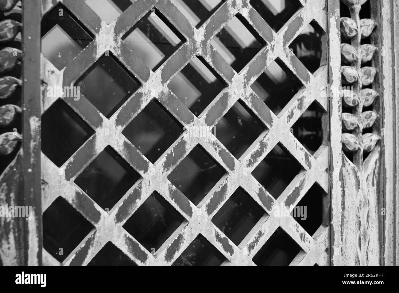 A decorative copper metal fence with a square grid pattern in a black ...