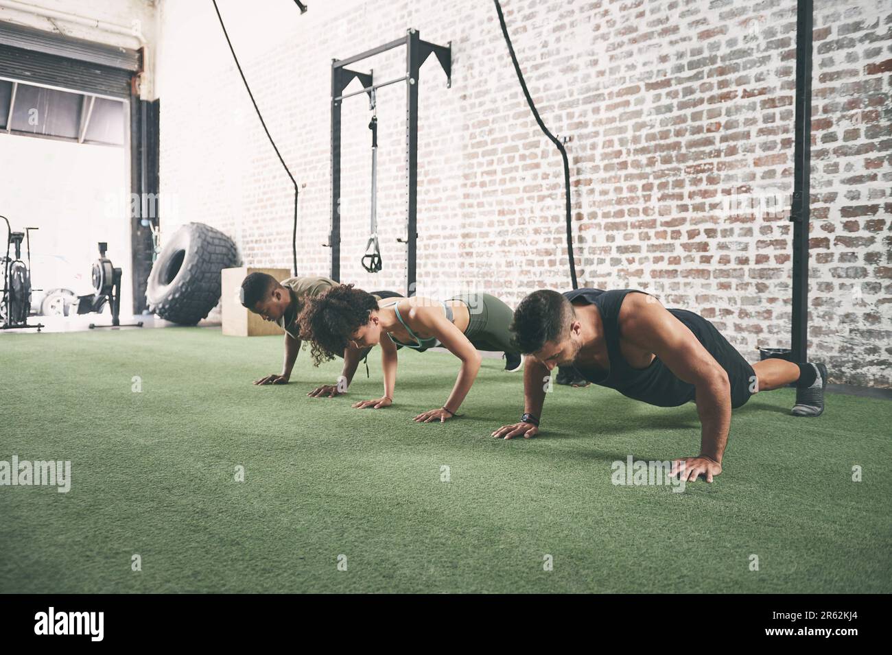 Get more involved in fitness. a fitness group doing push-ups at the gym ...