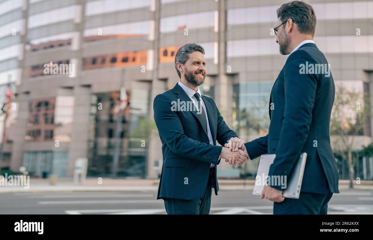 two business men handshaking outdoor, copy space banner. two business ...